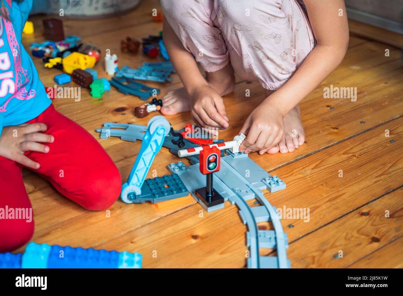 Girls, sisters play kids constructor, build toy railway, railroad by ...