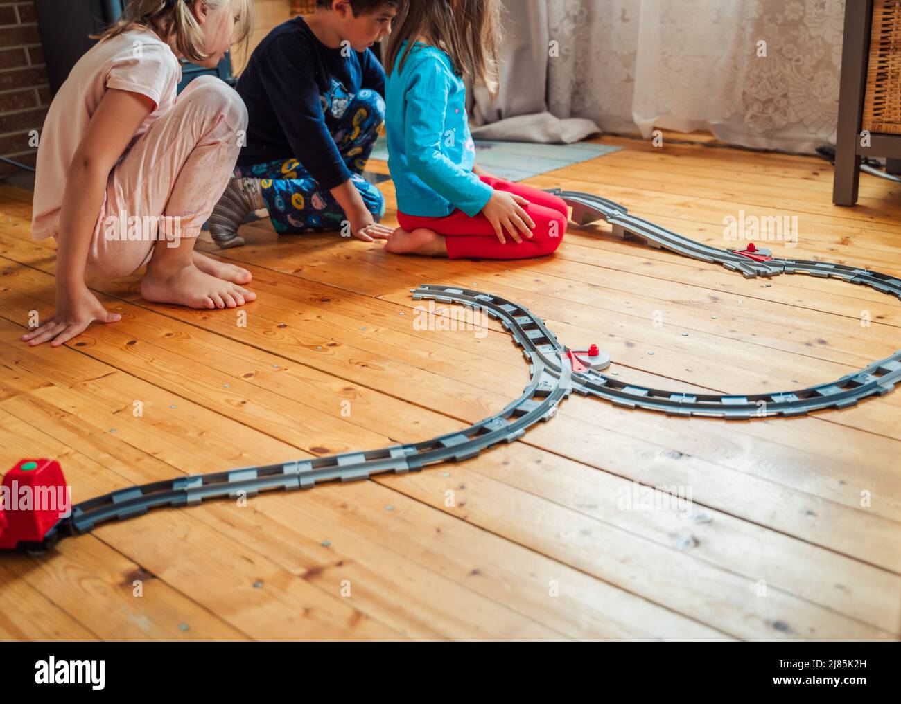 Girls, sisters play kids constructor, build toy railway, railroad by ...