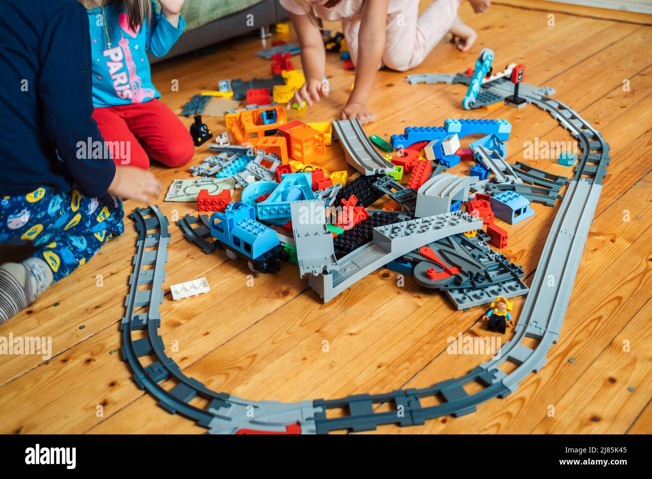 Girls, sisters play kids constructor, build toy railway, railroad by ...