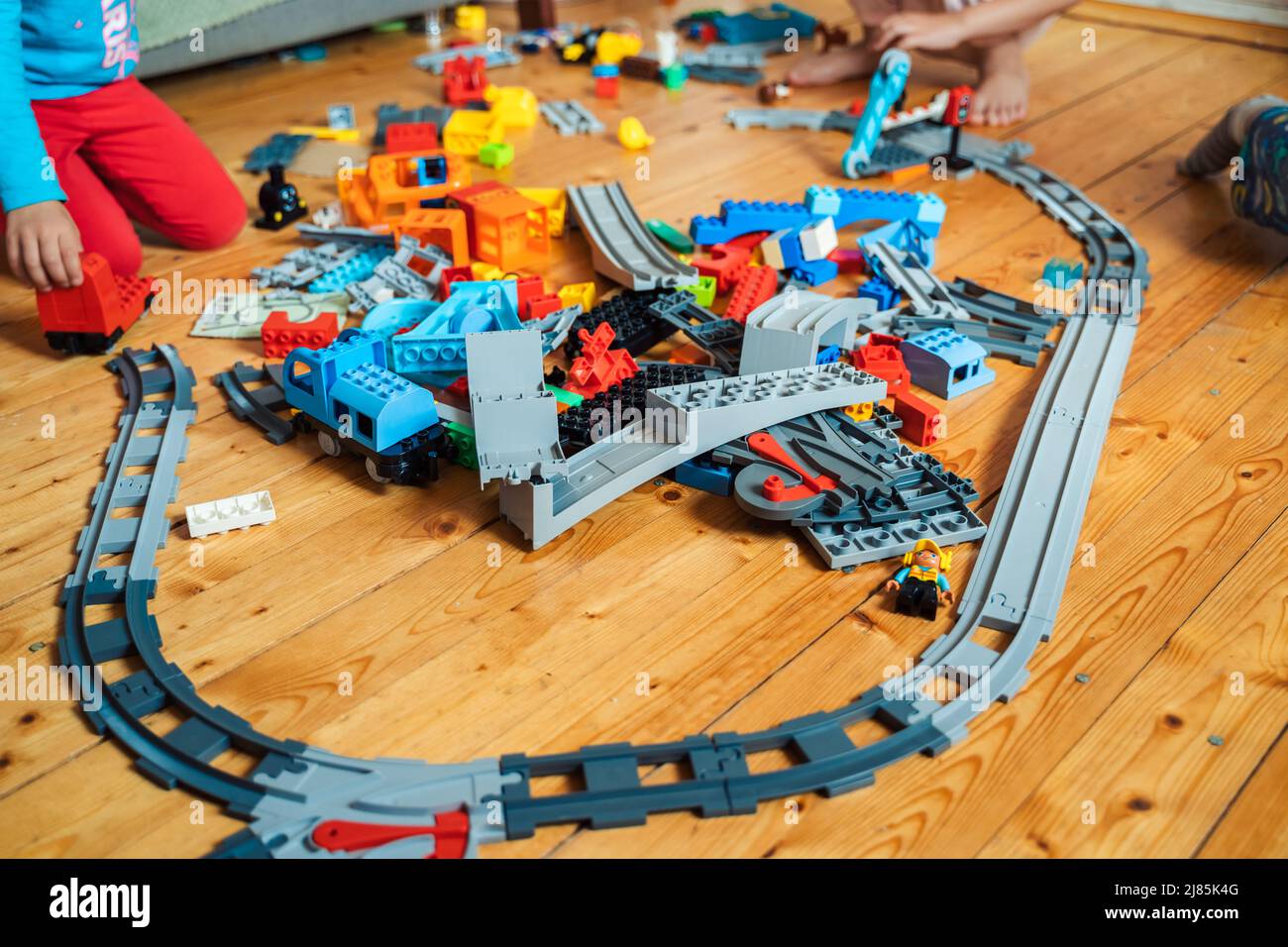 Girls, sisters play kids constructor, build toy railway, railroad by ...