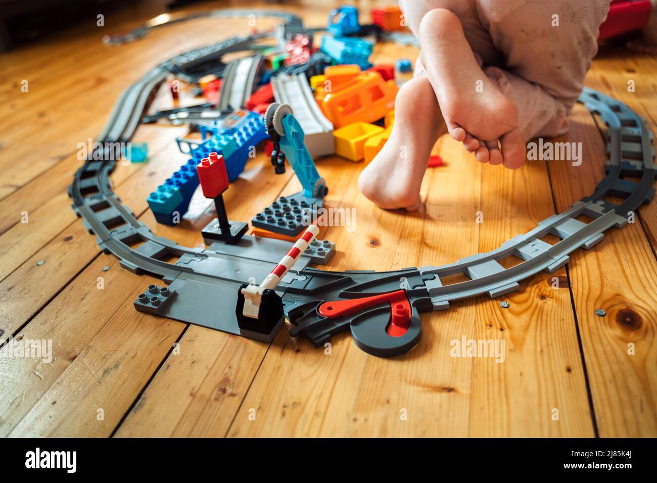Girls, sisters play kids constructor, build toy railway, railroad by ...