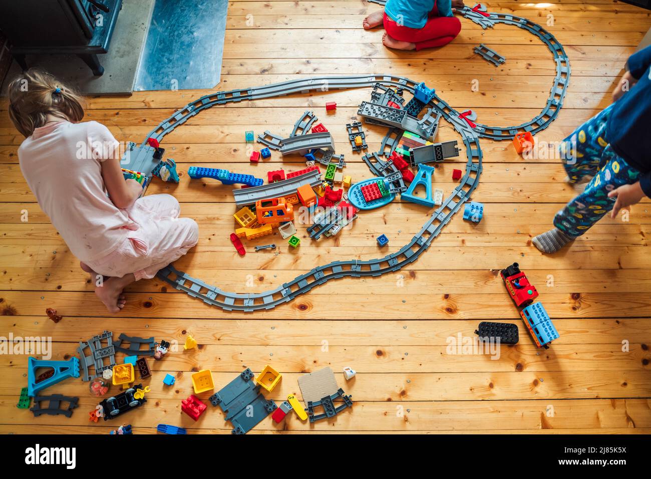 Girls, sisters play kids constructor, build toy railway, railroad by ...