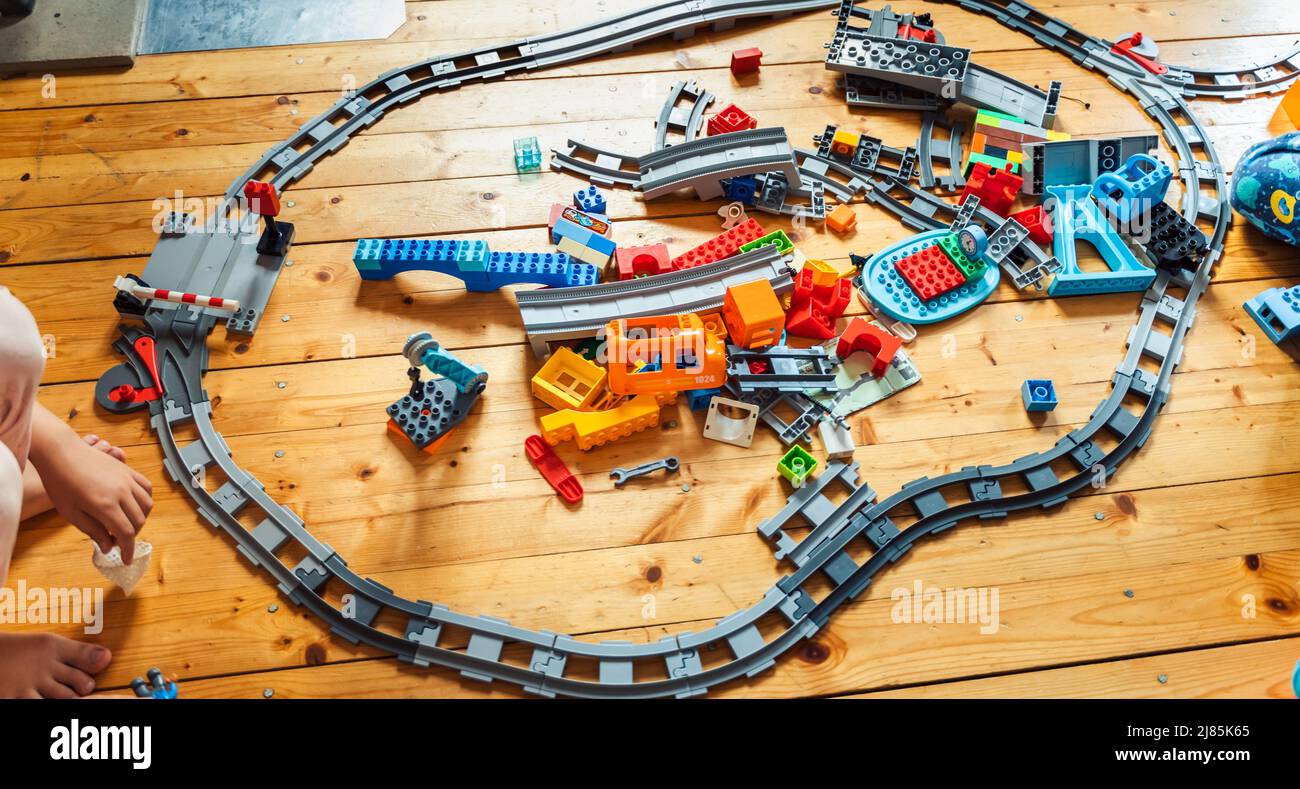 Girls, sisters play kids constructor, build toy railway, railroad by ...