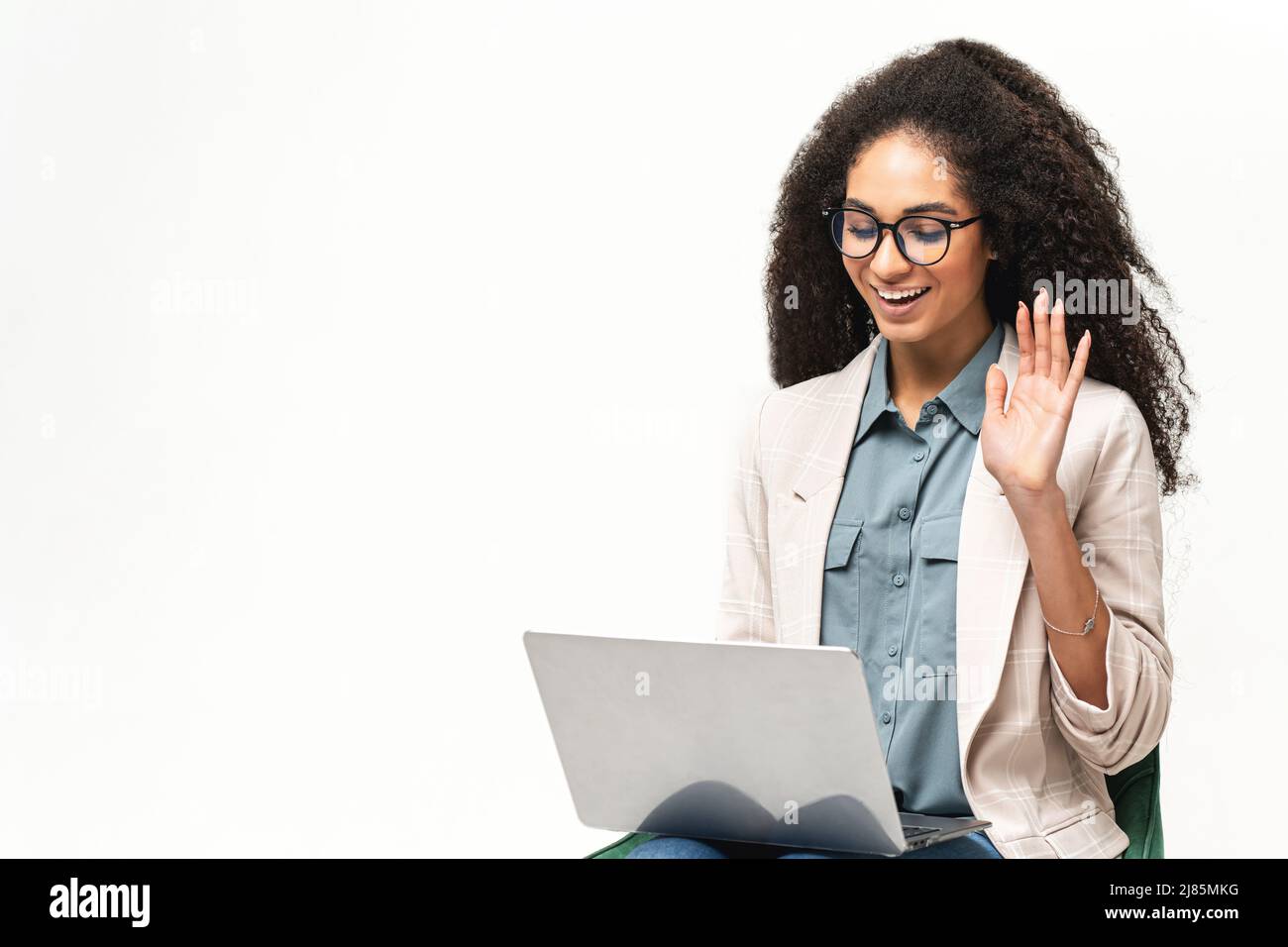 Confident multiracial woman in smart wear using laptop isolated on white background. Female ...