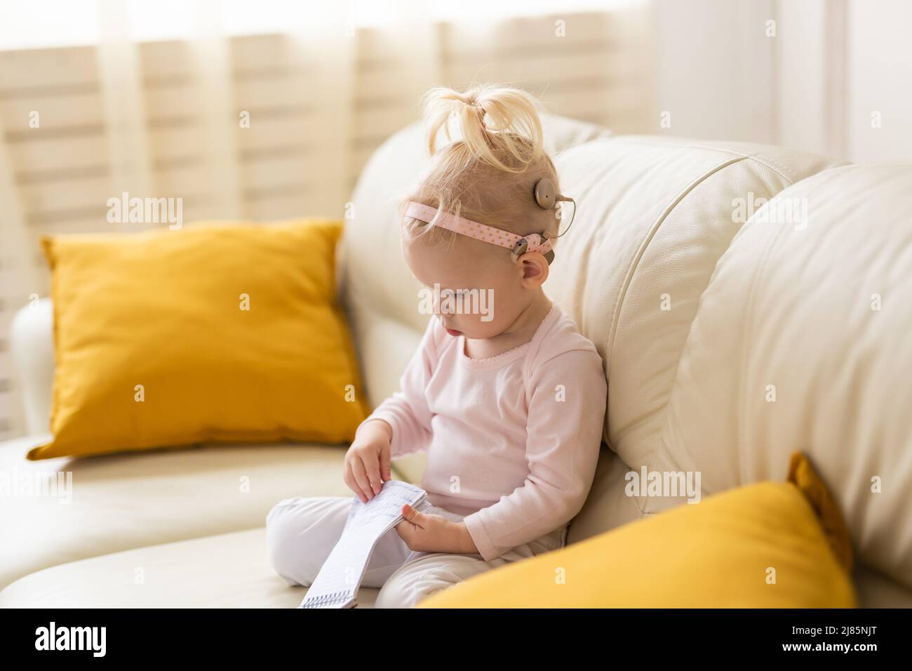 Cochlear implant for baby. Deaf child with hearing aid at home Stock ...