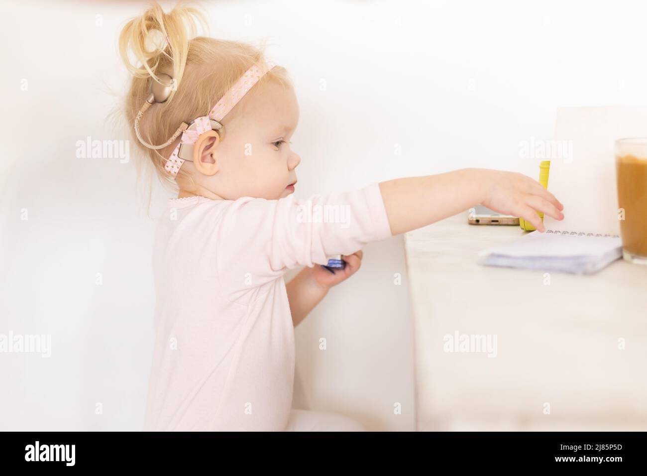 Cochlear implant for baby. Deaf child with hearing aid at home Stock ...
