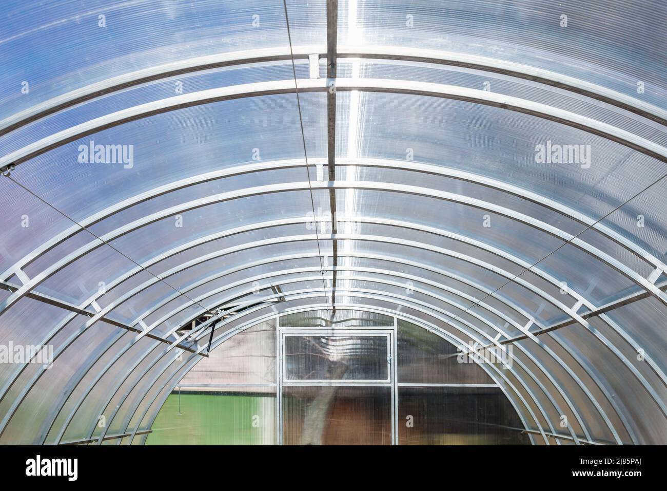 Modern greenhouse interior background. Polycarbonate roof mounted on ...