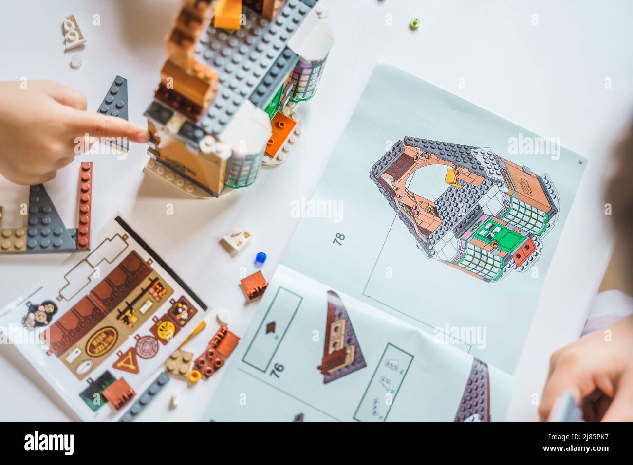 Girls, sisters play kids constructor, build house Lego Harry Potter ...