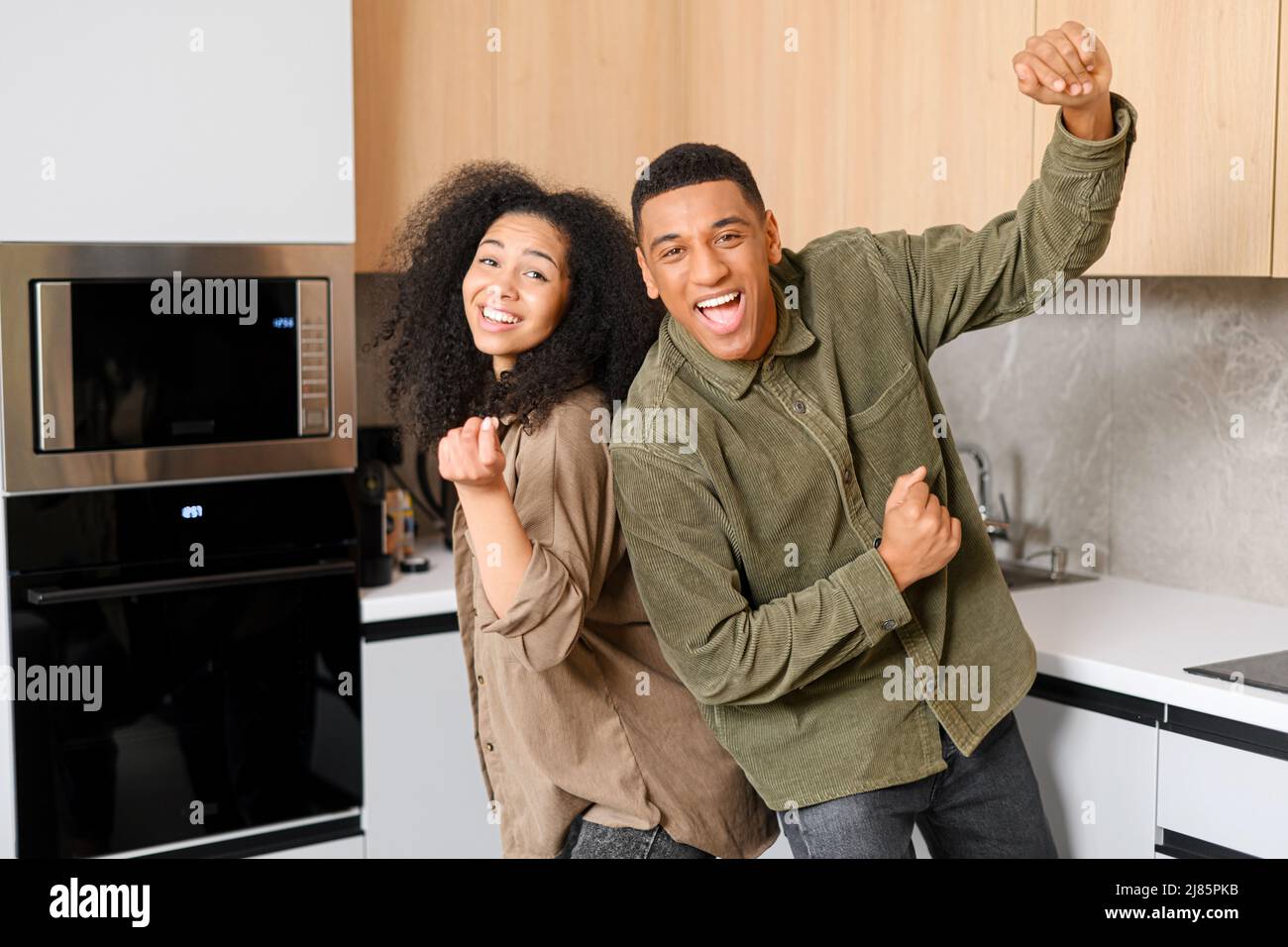 Portrait of joyful married couple laughing at home. Woman and her ...