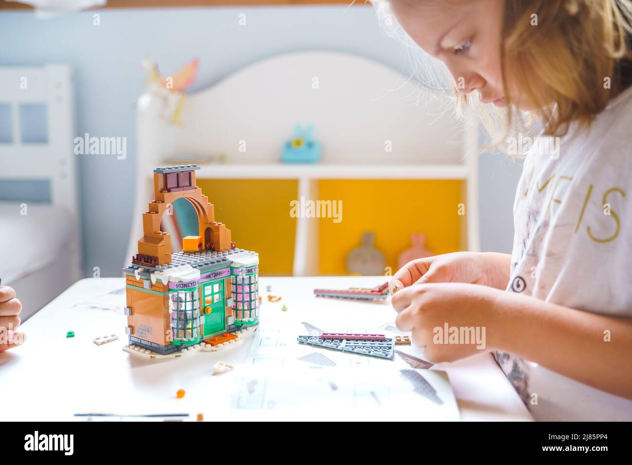 Girls, sisters play kids constructor, build house Lego Harry Potter ...