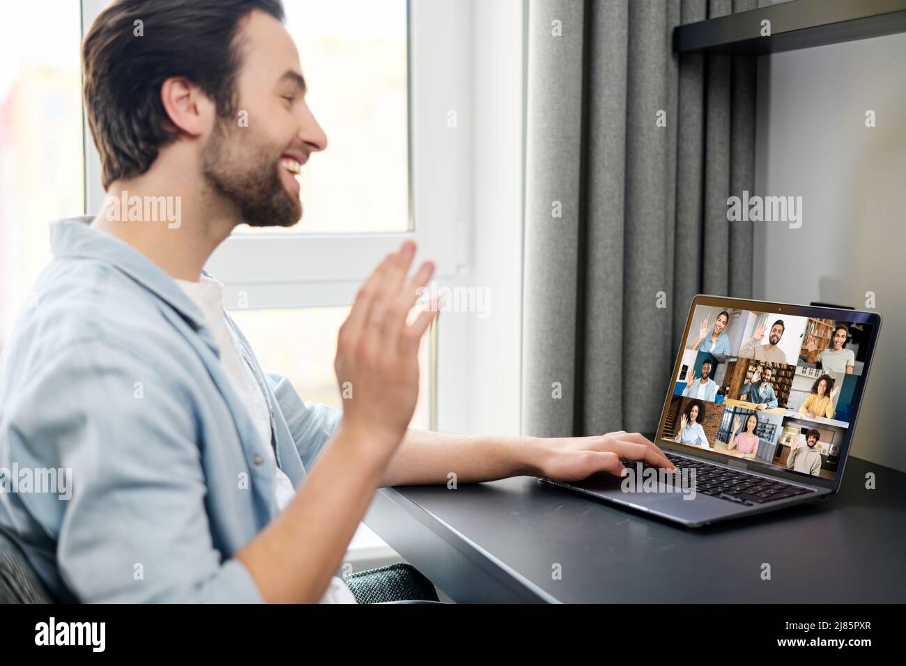 Virtual conference, webinar. Young cheerful caucasian man waves hello ...