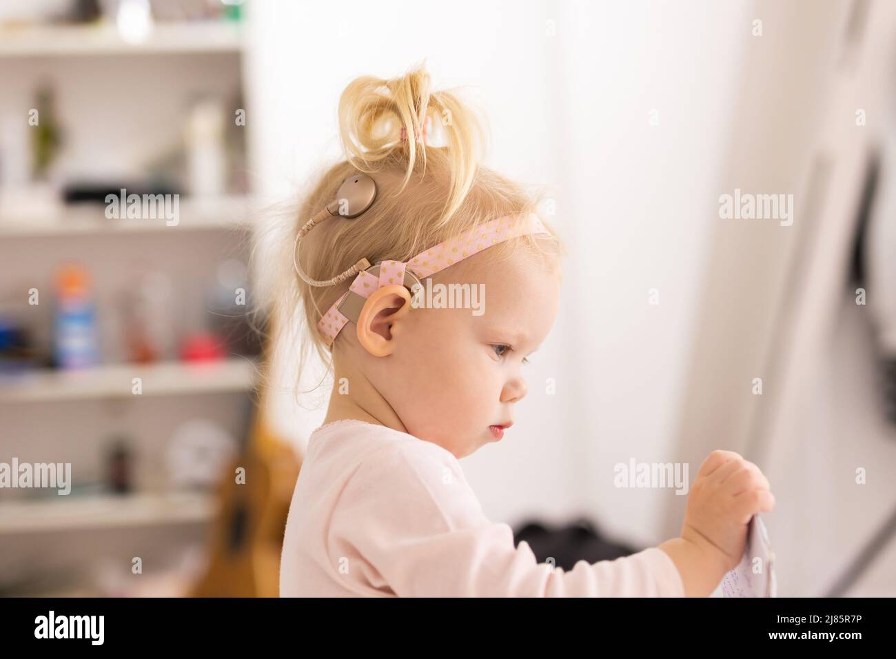 Cochlear implant for baby. Deaf child with hearing aid. Health care and ...