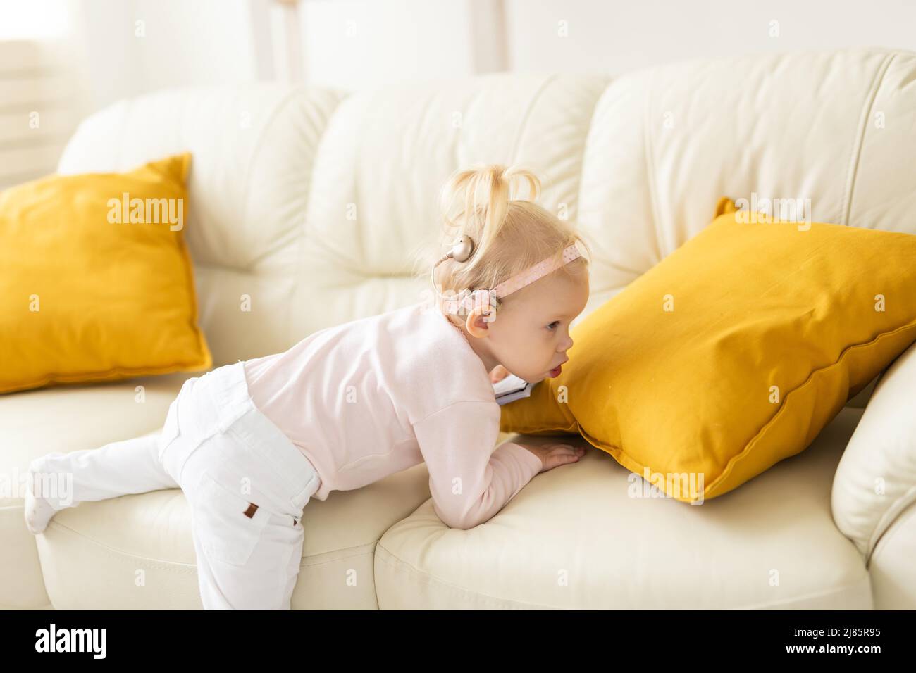 Cochlear implant for baby. Deaf child with hearing aid at home Stock ...