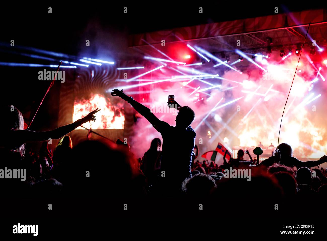 Rock concert, silhouettes of happy people raising up hands, man makes ...