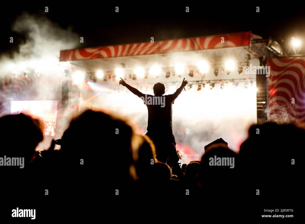 Silhouette of a man who enjoys a concert, hands up Stock Photo - Alamy
