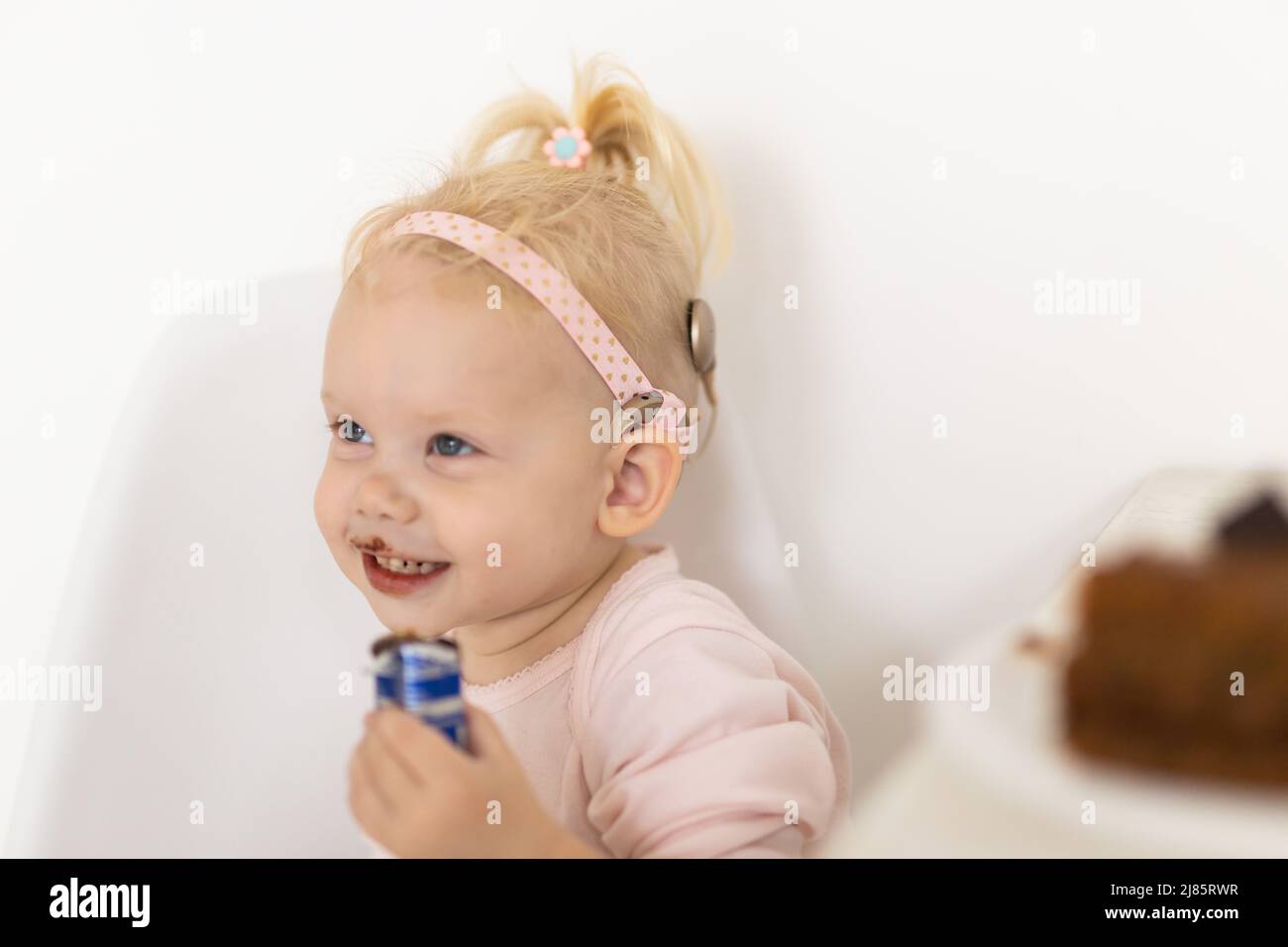 Cochlear implant for baby. Deaf child with hearing aid at home Stock ...