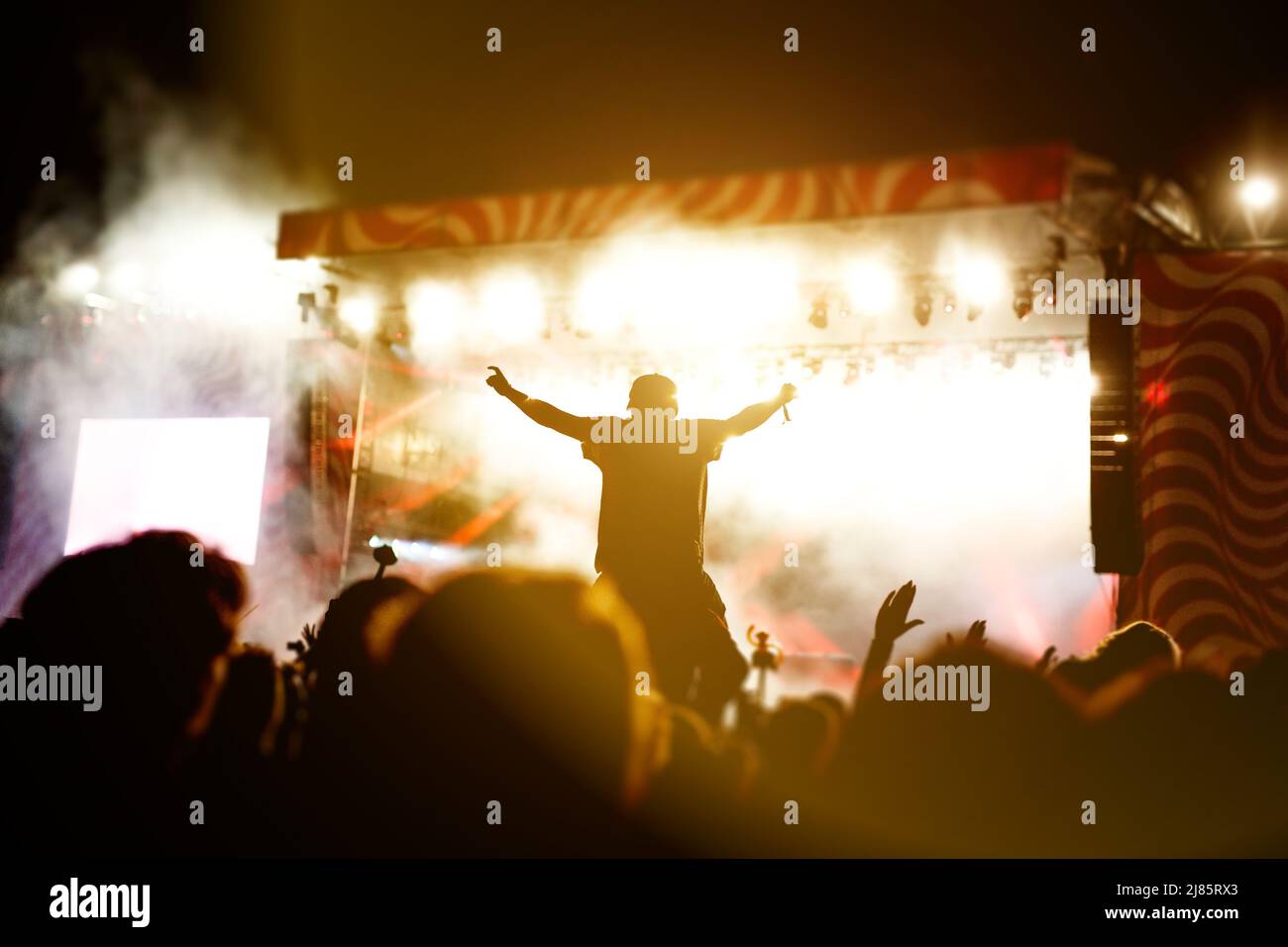Silhouette of a man who enjoys a concert, hands up Stock Photo - Alamy