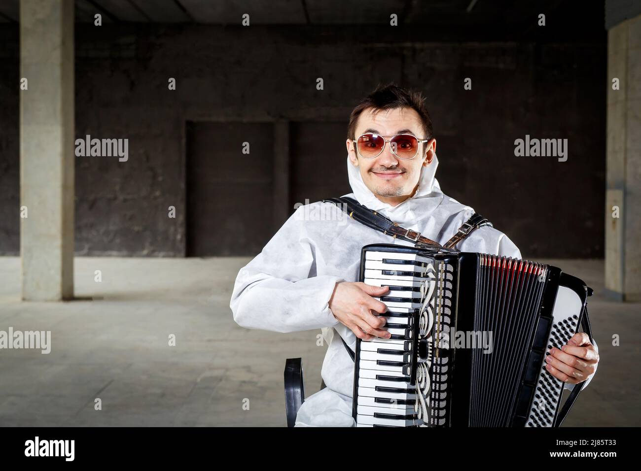 The musician playing the harmonica, accordion in the hall with black ...