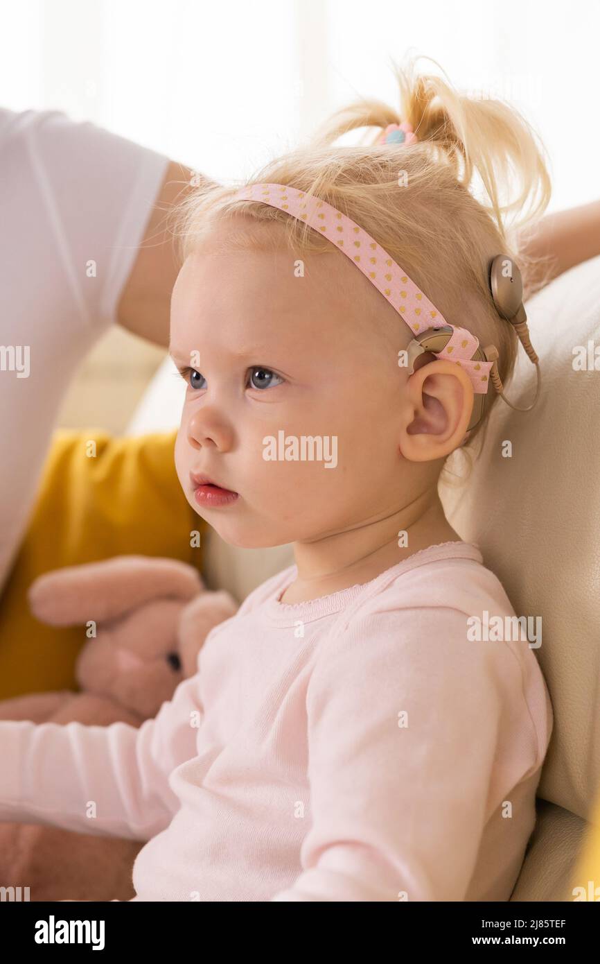 Cochlear implant for baby. Deaf child with hearing aid. Health care and ...