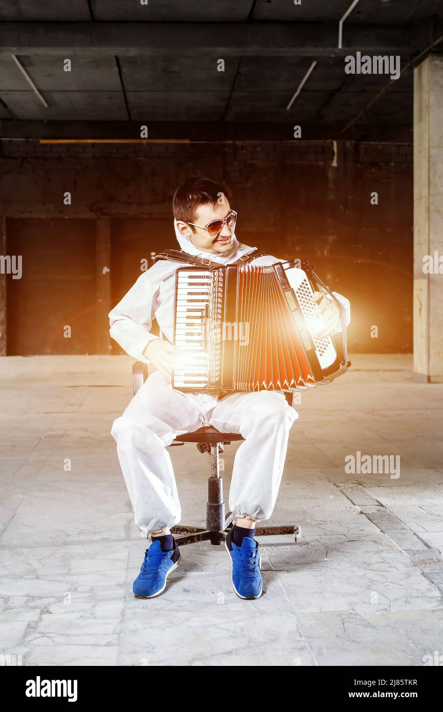The musician playing the harmonica, accordion in the hall with black ...