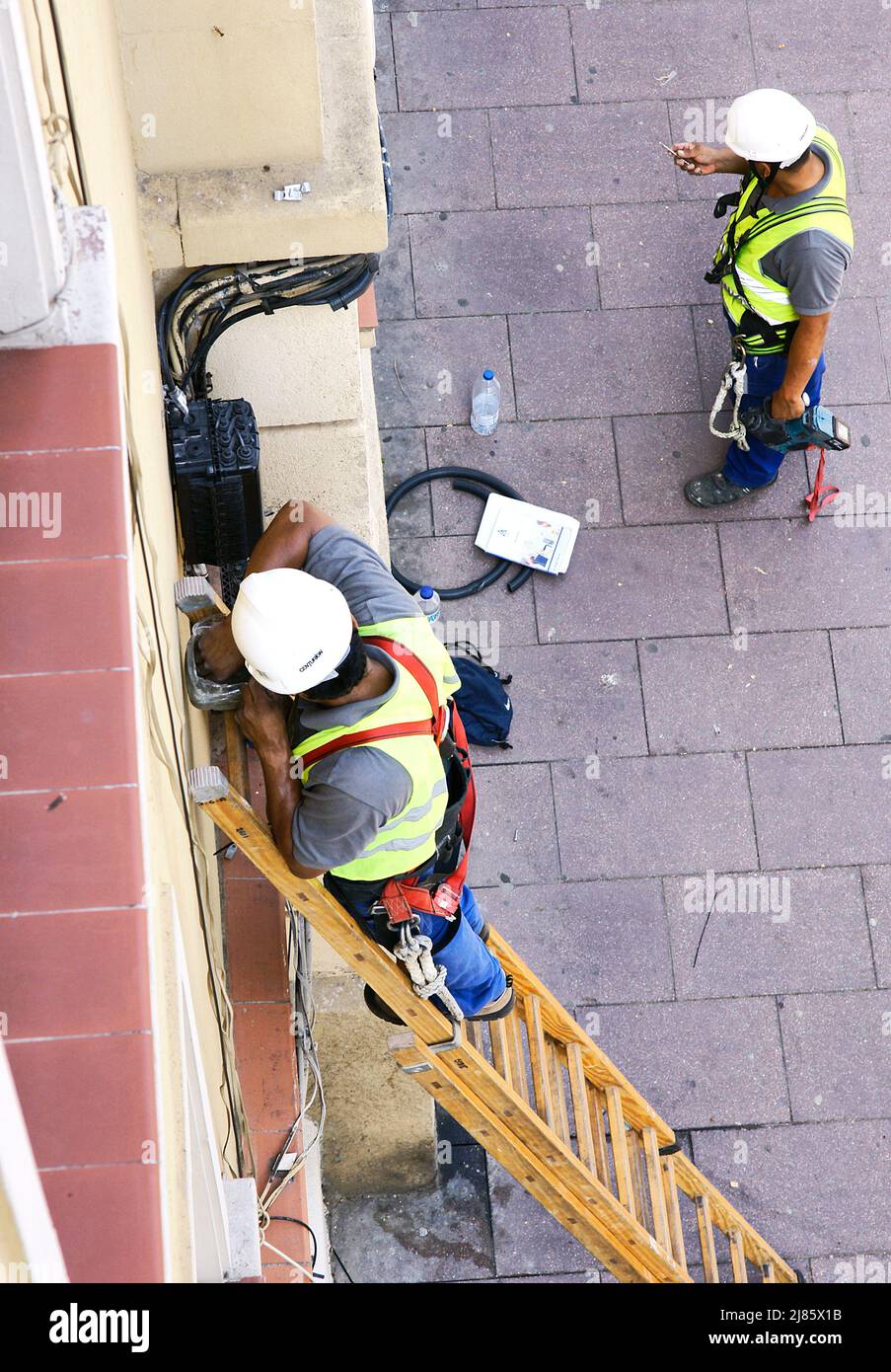 Workmen repairing telephone lines on a street in Barcelona, Catalunya ...