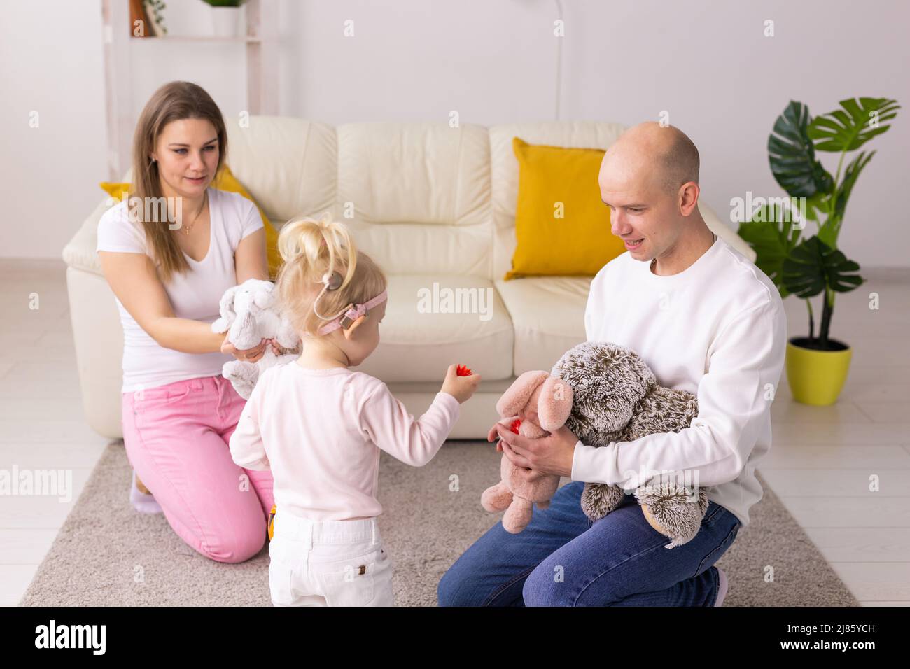 Happy child girl with cochlear implant having fun with her family ...