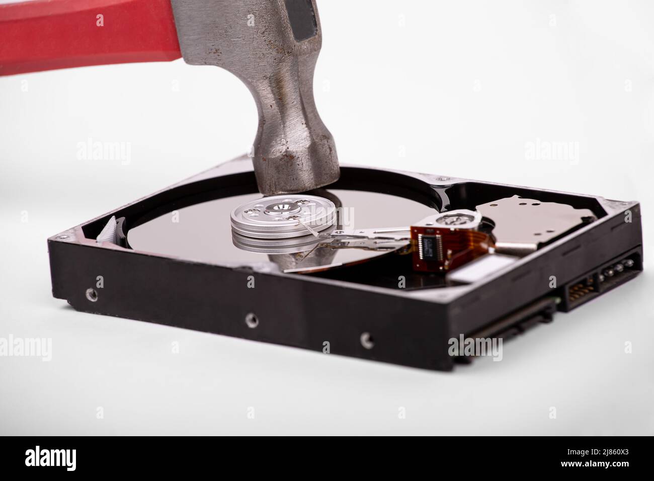 The hammer hits the plate of an open hard drive. Destruction of ...