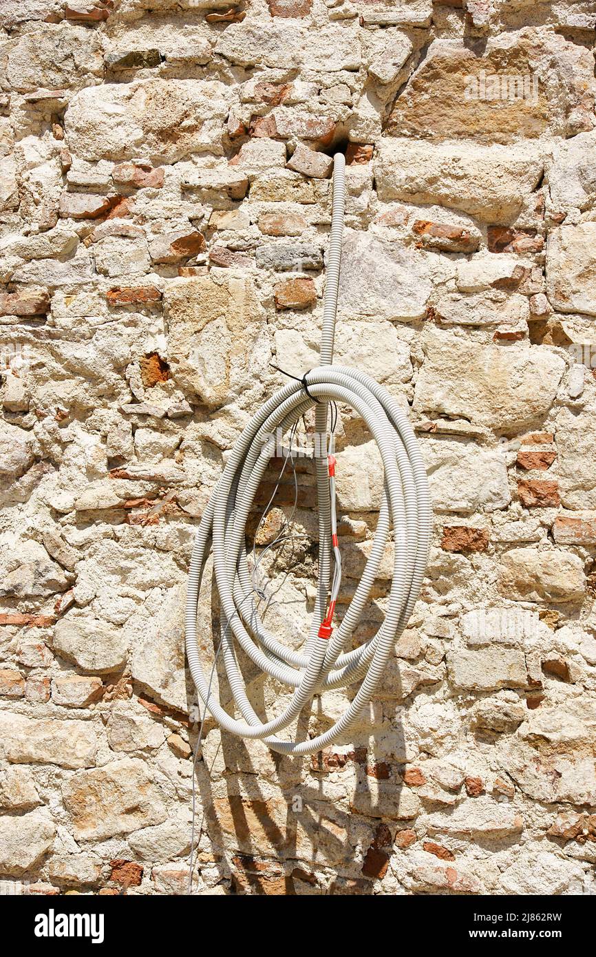 Electric cable hanging from a wall in the Pueblo Nuevo neighborhood in ...