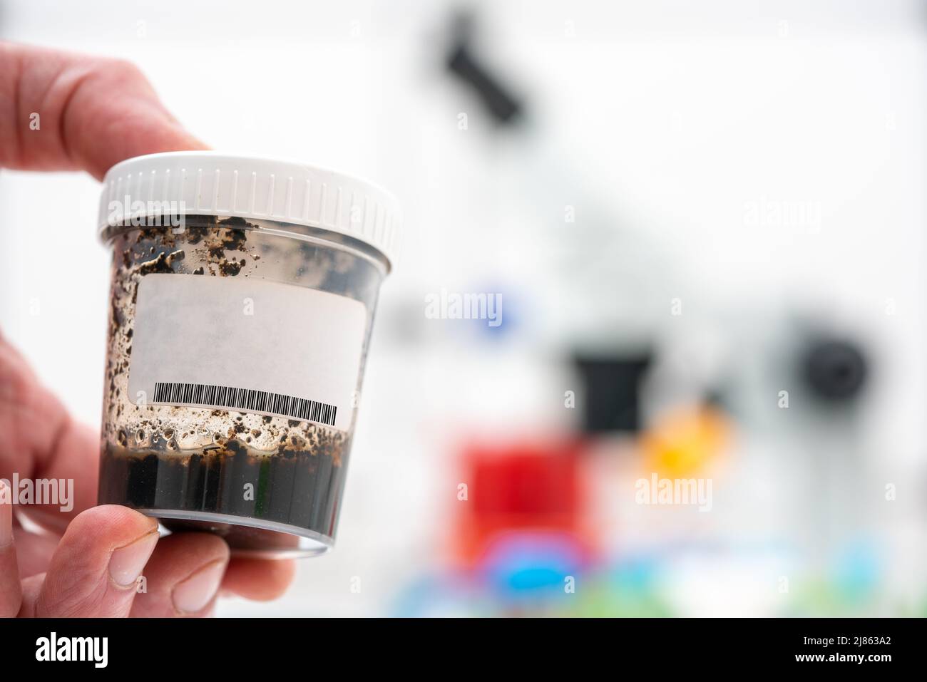 scientist ecologist holds a container with a soil sample for chemical ...