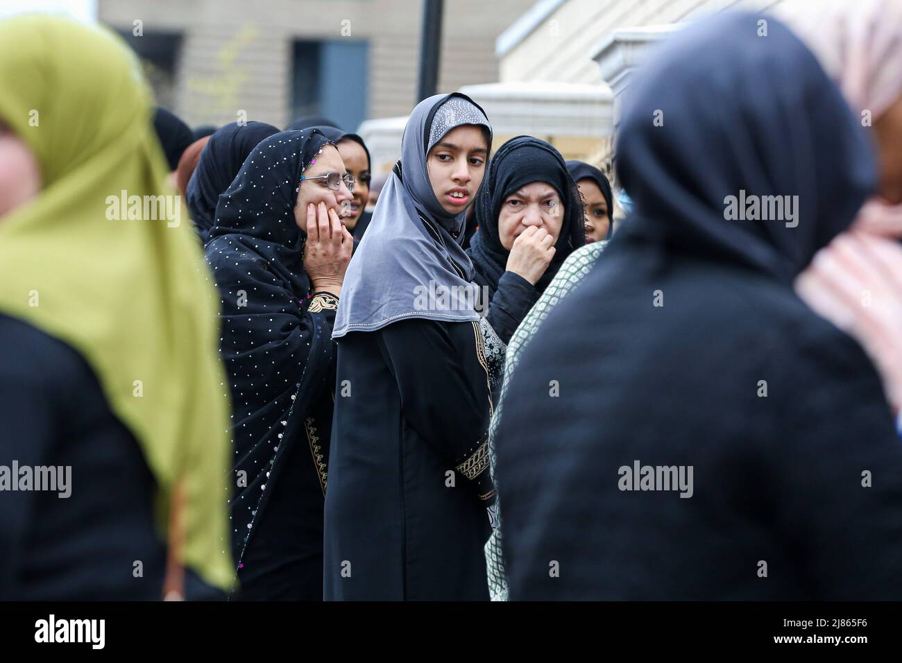 Muslim women gather outside a mosque after attending morning prayers ...