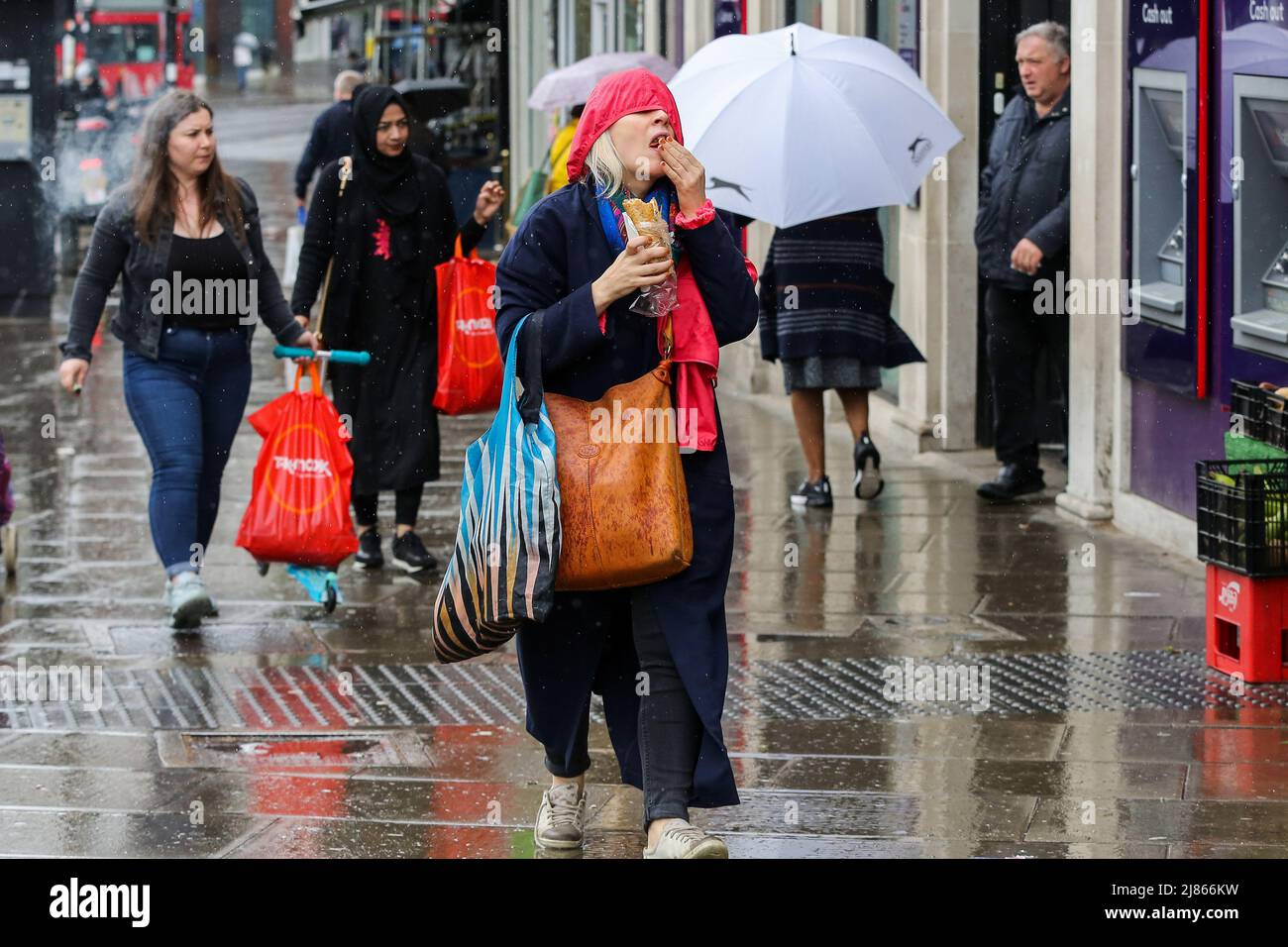 A woman seen eating while walking on the Streets of London Stock Photo ...