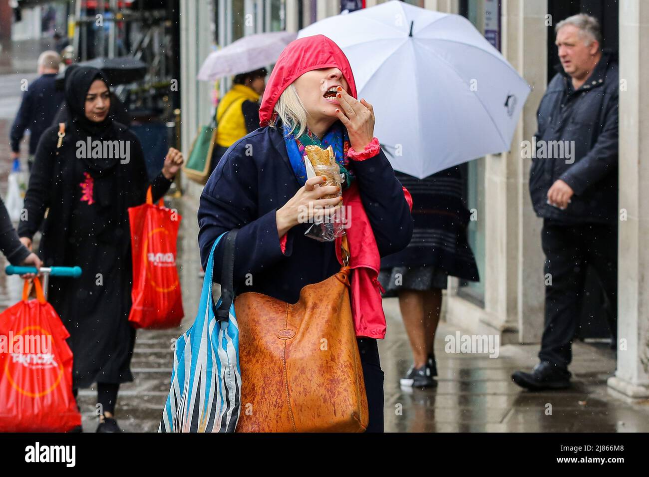 A woman seen eating while walking on the Streets of London Stock Photo ...