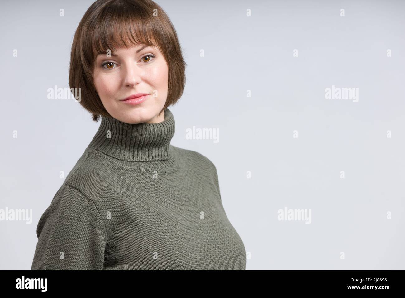 portrait of young and pretty woman in front of a grey background Stock ...