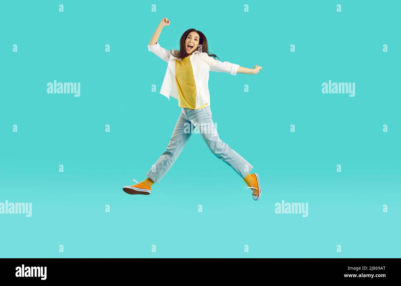 Happy joyful excited beautiful young woman in casual wear jumping high ...