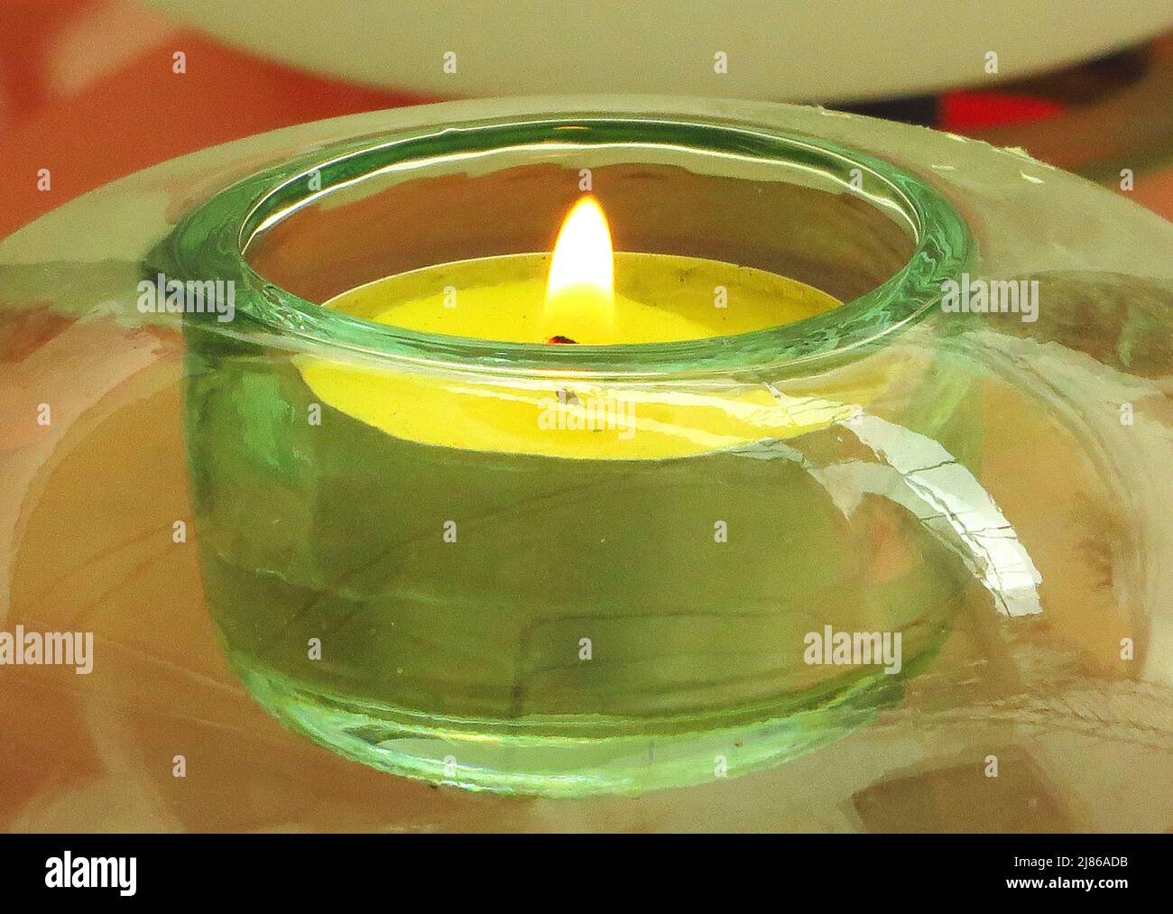 Lit candle in a glass container Stock Photo - Alamy