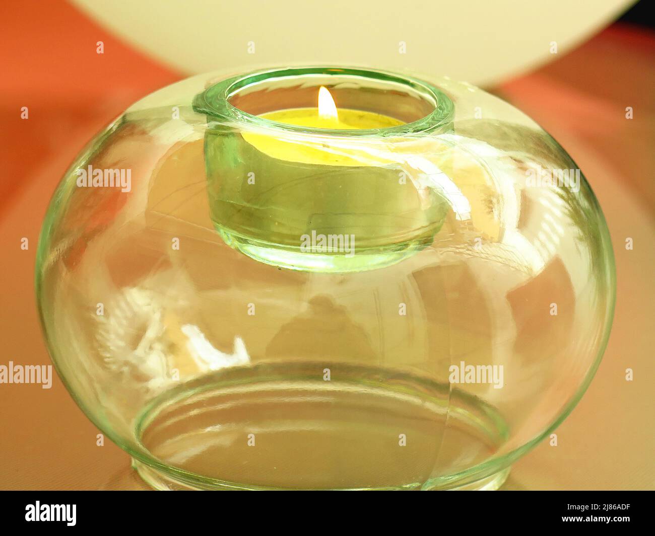 Lit candle in a glass container Stock Photo - Alamy
