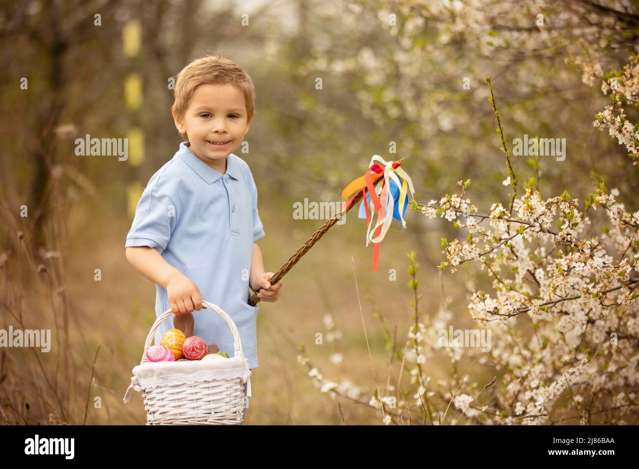 Cute preschool child, whipping his sister on Easter with twig, braided ...
