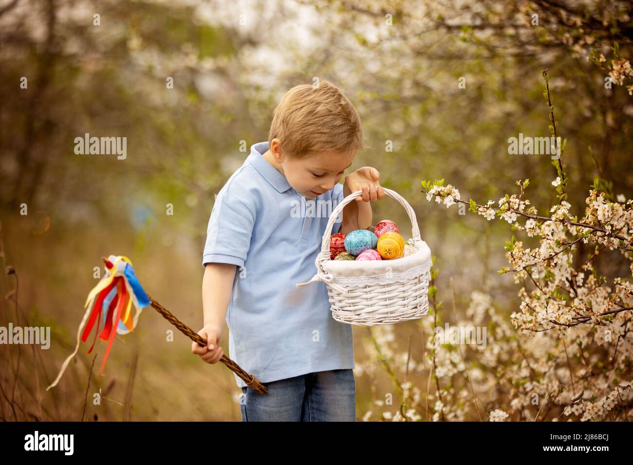 Cute preschool child, whipping his sister on Easter with twig, braided ...