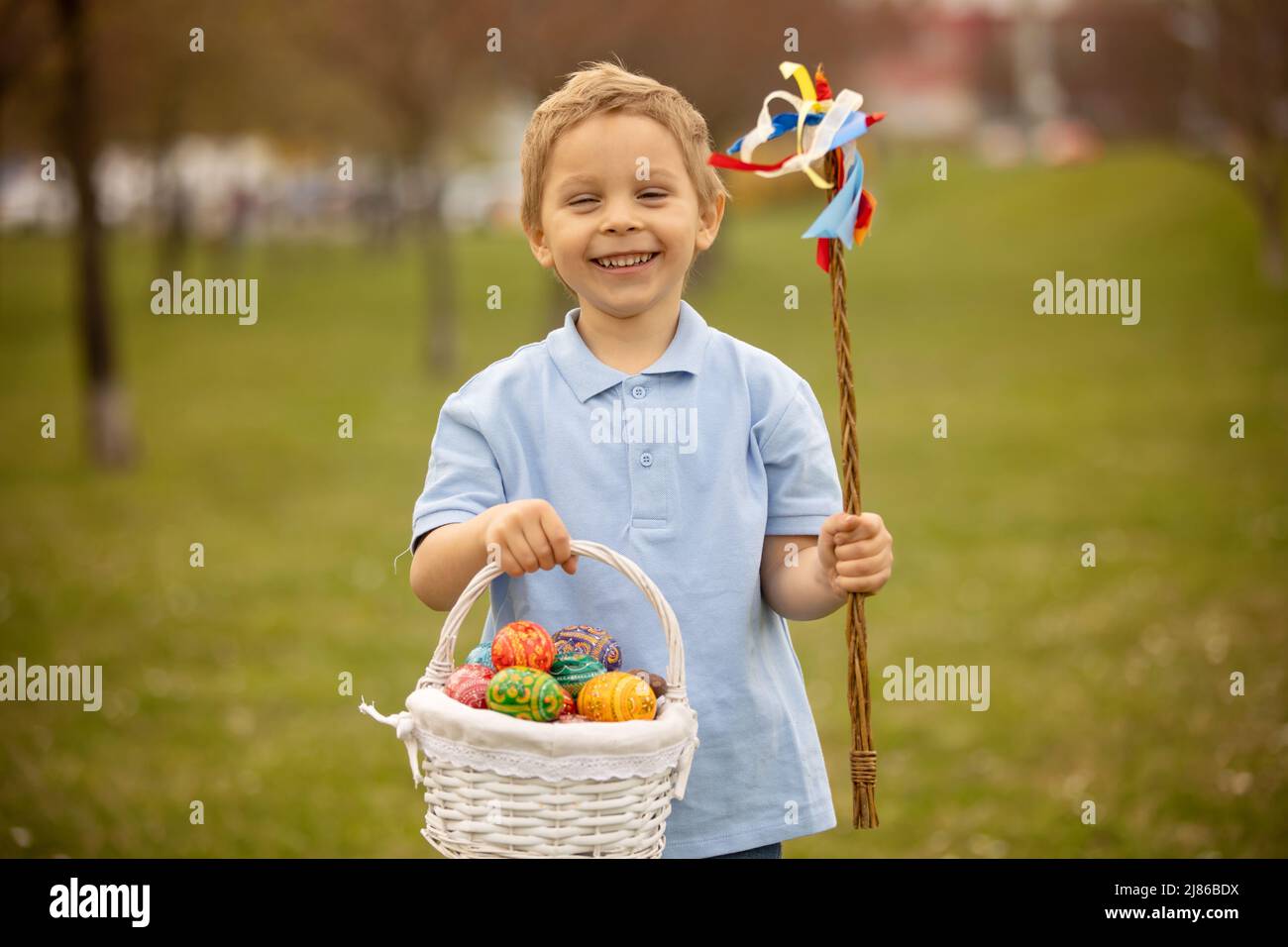 Cute preschool child, whipping his sister on Easter with twig, braided ...
