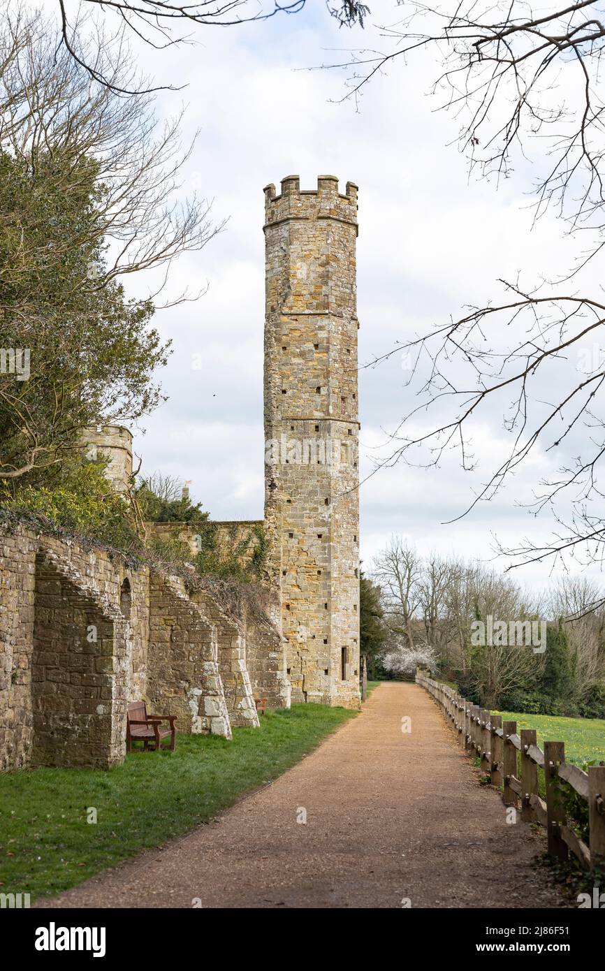 Looking along a stone pathway at a tall cream stone tower at the end of ...