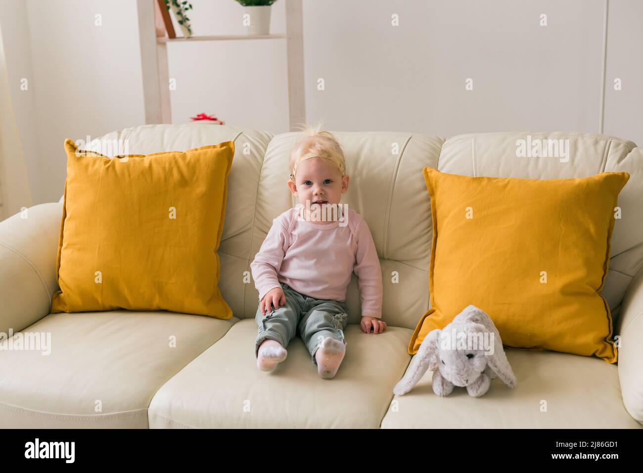 Kid with cochlear implants sits on sofa at home. Deafness and medical ...