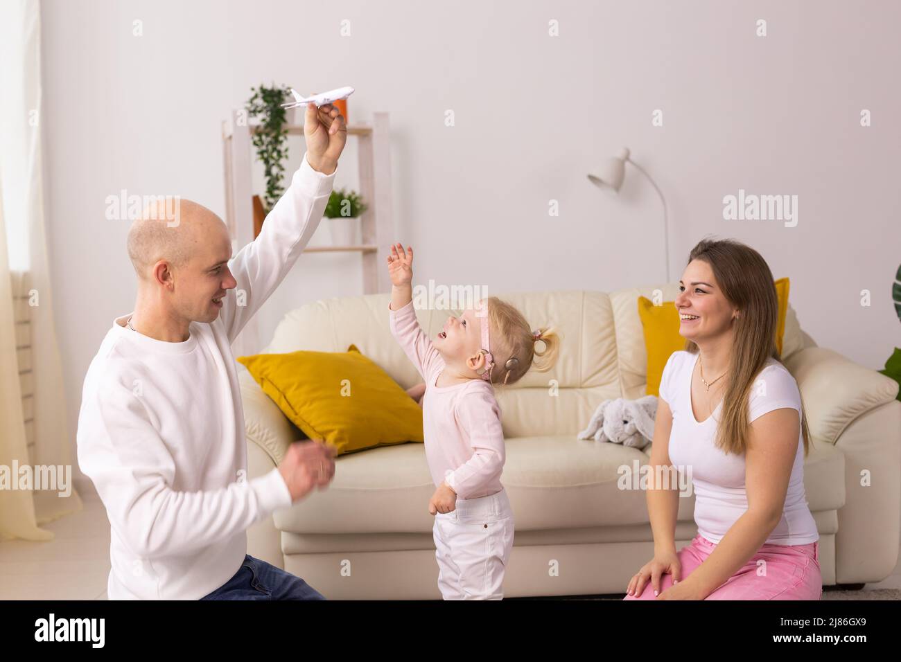 Baby child with hearing aids and cochlear implants plays with parents ...