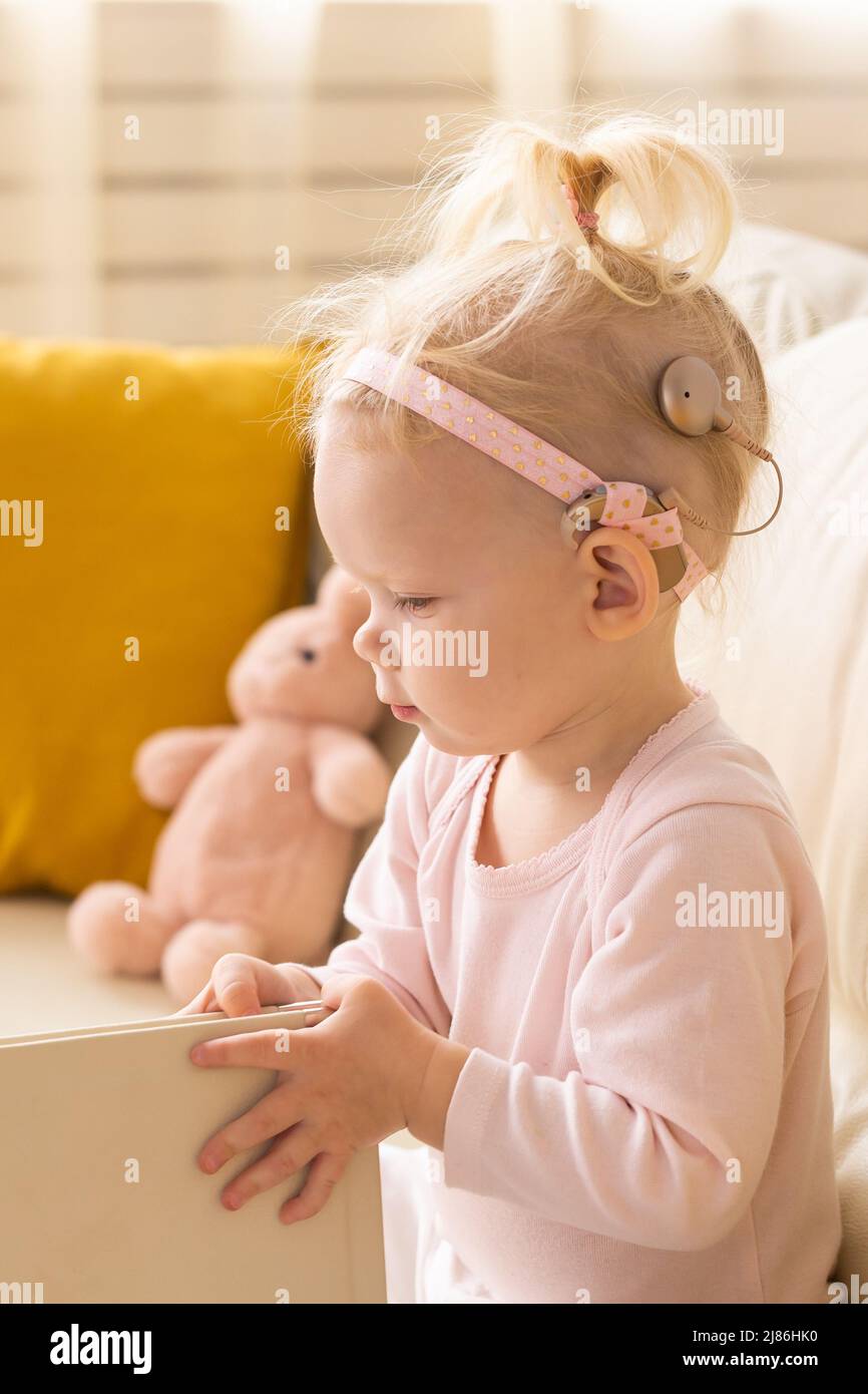 Baby with cochlear implants having fun at home. Deafness and medical ...