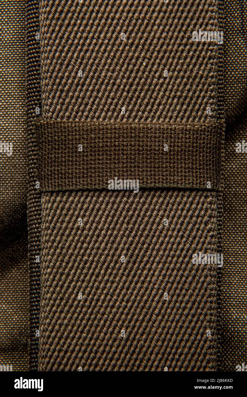 Close-up texture of a canvas fabric backpack. Leather straps and metal ...