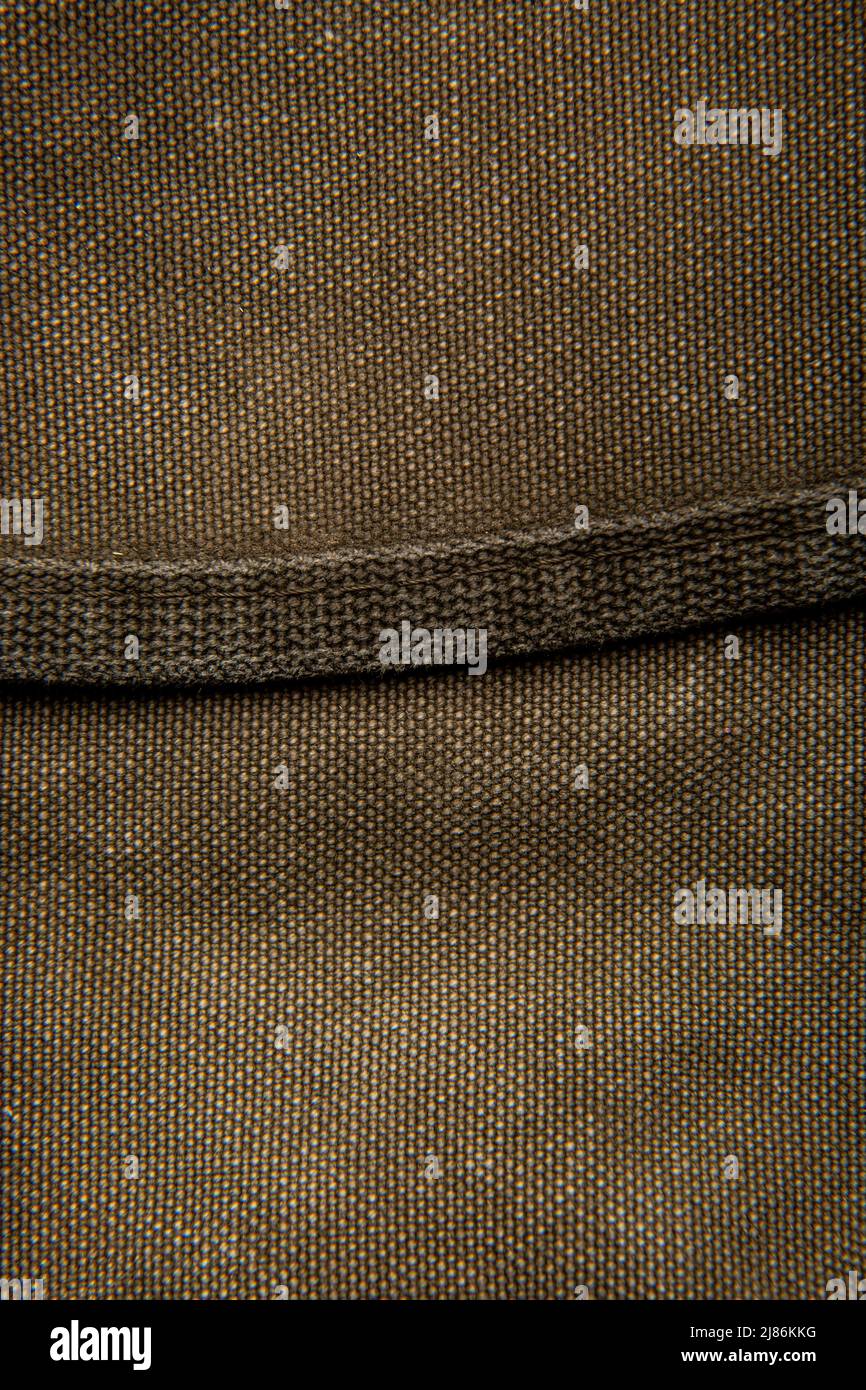 Close-up texture of a canvas fabric backpack. Leather straps and metal ...