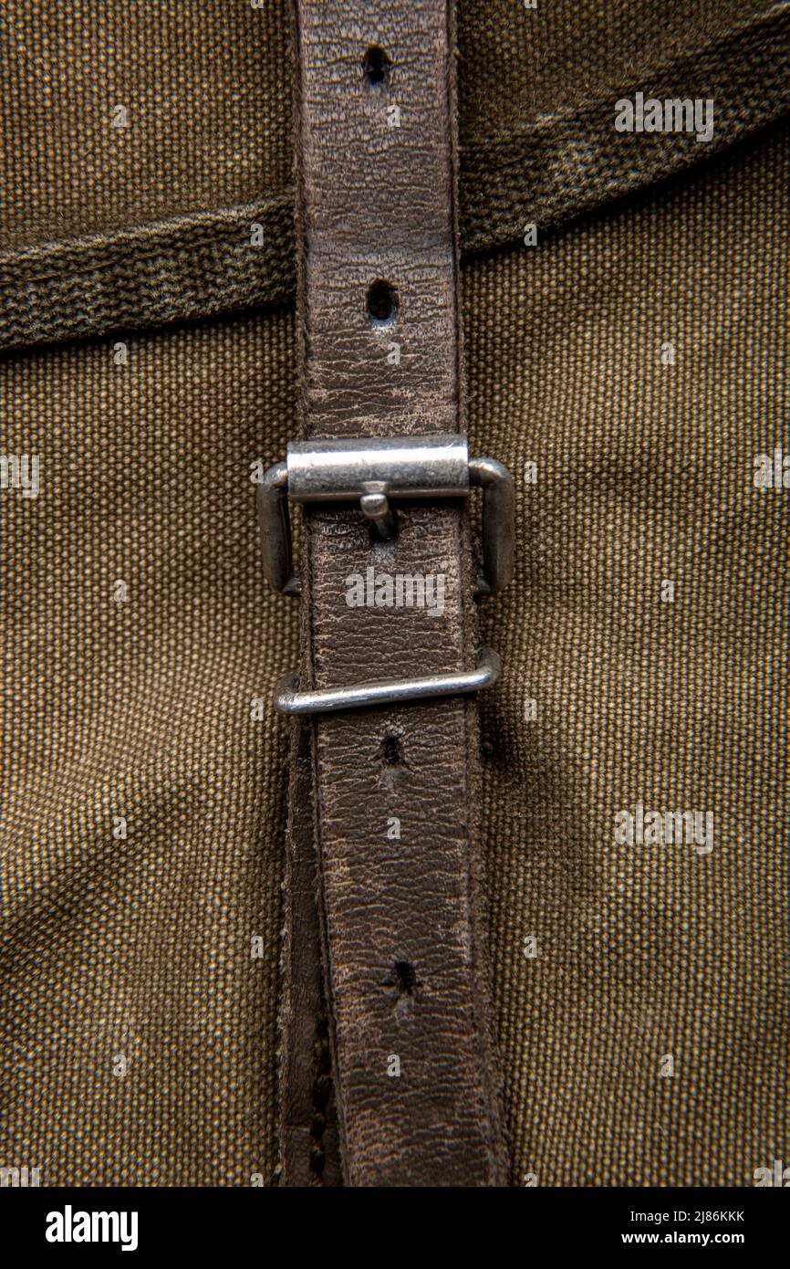 Close-up texture of a canvas fabric backpack. Leather straps and metal ...