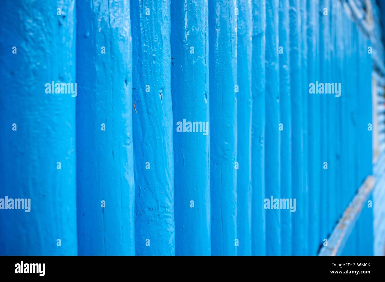 Vertical log wall in blue, outdoors. Wooden building Stock Photo - Alamy