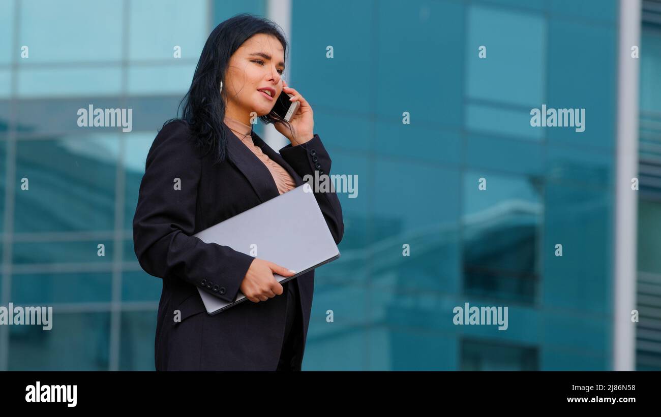 Successful young businesswoman walks down street against background of ...