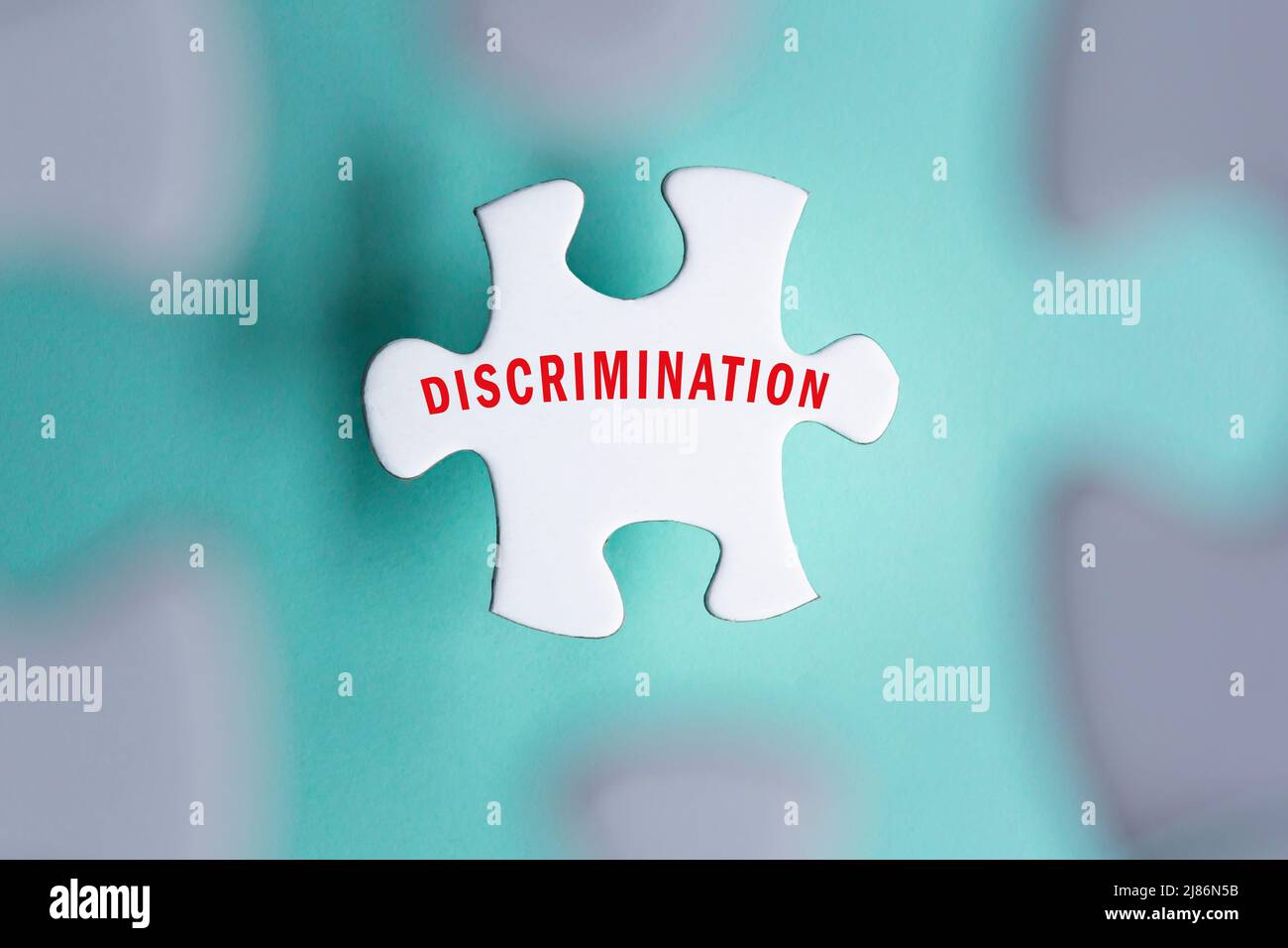 Discrimination word on puzzle pieces isolated on blurred green ...