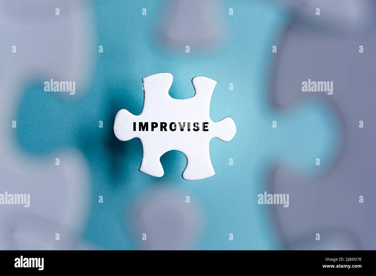 Improvise word on puzzle pieces isolated on blurred blue background ...